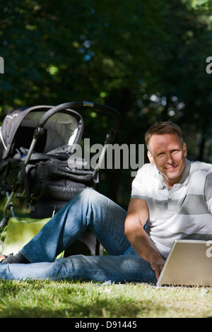A man with a pram and a computer in a park a sunny day, Sweden Stock ...