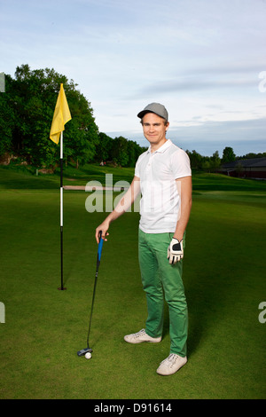 Smiling young man standing with flag and multidirectional arrows around ...