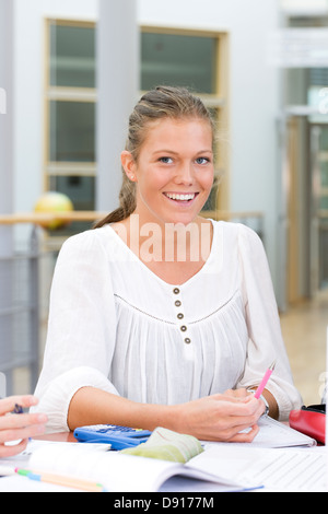 Portrait o young smiling student in a library Stock Photo - Alamy