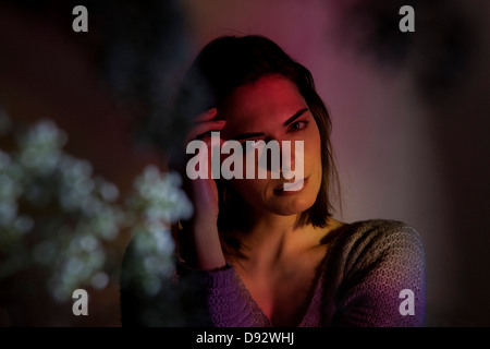 A woman looking suggestively into the camera while touching her hair ...