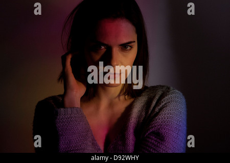 A woman looking suggestively into the camera while touching her hair ...