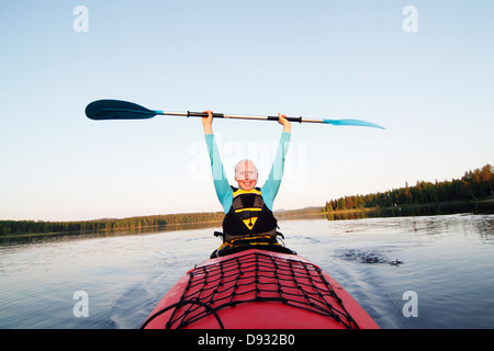 Young smiling woman paddling on a SUP - stand up paddle board, while ...