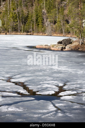 Hole in thin ice on a frozen lake, abstract winter background photo ...