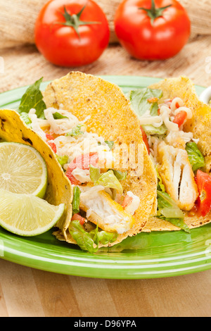 Tasty fish taco on plate with sauce and chips on white wooden ...