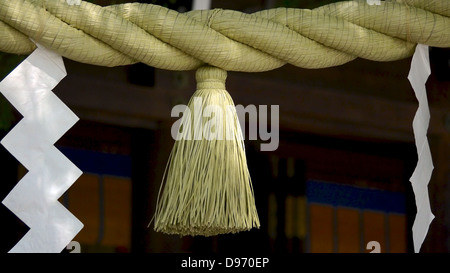 A sacred rice straw rope (shimenawa) marks the entrance to a Shinto ...