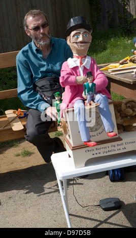 Man operating a traditional wooden jig doll dancer during a country ...