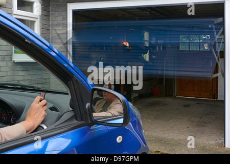 Woman car driver operating Henderson remote control to open or close ...