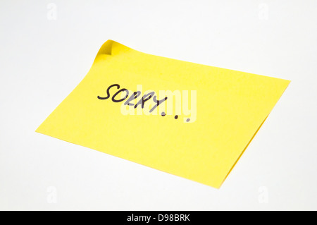 Apology. Sticky note with word Sorry and drawn sad face pinned on white ...