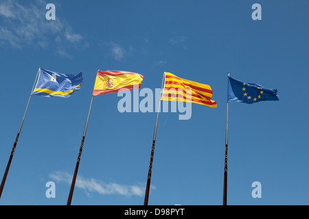 Flags of Spanish regions on flagpoles against blue sky, Salou ...