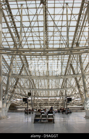 Travelers sitting in the atrium waiting area at Charles de Gaulle train ...