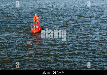 Bright red maritime buoy in the middle of the ocean, surrounded by blue ...