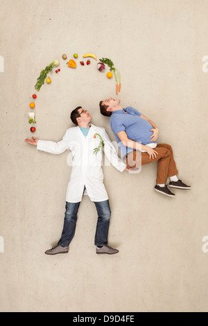 Man throwing fruits in another mans mouth Stock Photo - Alamy