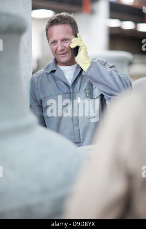 Warehouse worker talking on phone Stock Photo - Alamy