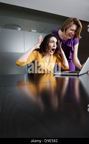 Young woman reacting in shock and horror with her mouth agape and hands ...