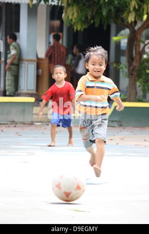 Boys chasing ball Stock Photo - Alamy