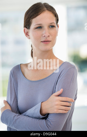 Woman standing with arms crossed on blue background Stock Photo - Alamy