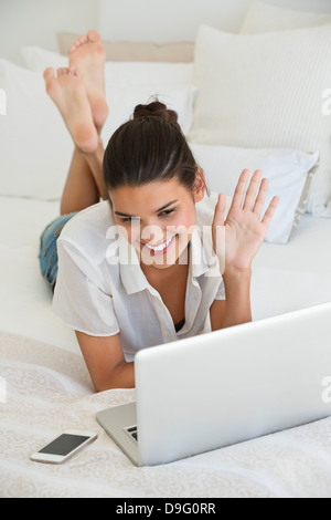 Young hispanic woman having video call sitting on table at home Stock ...