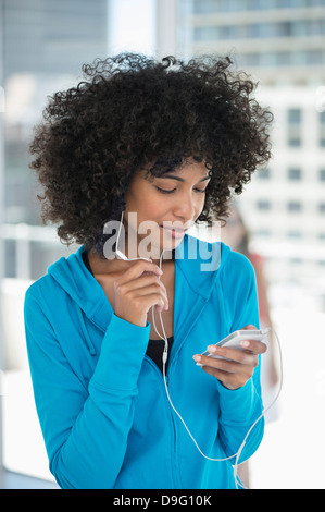 a woman is listening to her cell phone Stock Photo - Alamy