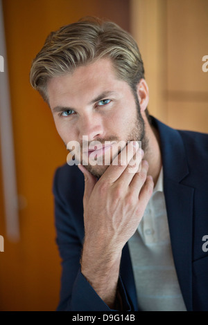 Vertical waist up portrait of handsome bearded young man holding red ...