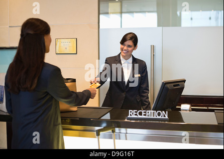 Receptionist and businesswoman at hotel front desk Stock Photo - Alamy