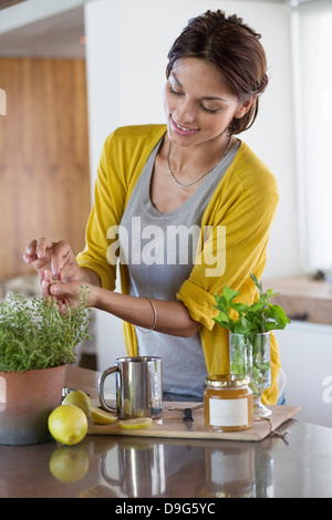 Woman making tea in kitchen Stock Photo - Alamy