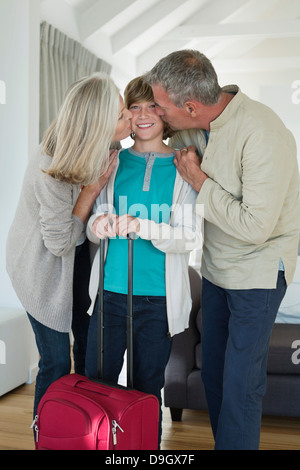 Grandparents kissing child while standing in kitchen Stock Photo - Alamy
