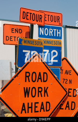 Construction road signs stacked up along the side of a street Stock ...