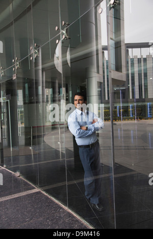 smiling businessman at office glass wall Stock Photo - Alamy