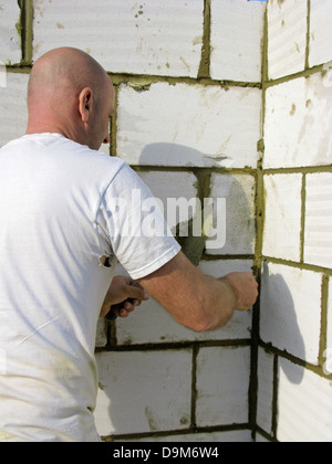 Builder laying bricks on construction site Stock Photo - Alamy