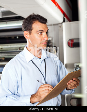 Young mechanical engineer taking readings of control equipment. Young ...