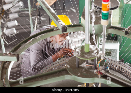 African American mechanic repairing industrial sewing machine in Stock ...