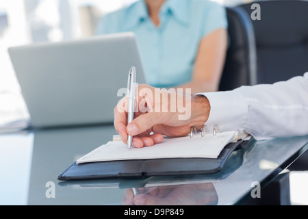 Close up of businessman writing on clipboard Stock Photo - Alamy