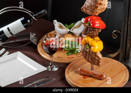 Big tasty roasted meat cuts at skewer on a decorated table Stock Photo ...