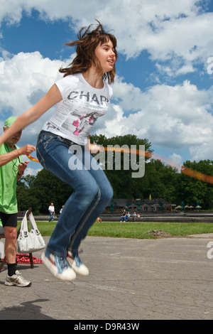 Girl jumping over a skipping rope Stock Photo - Alamy
