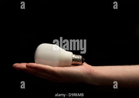 Hand holding white economic light bulb Stock Photo - Alamy
