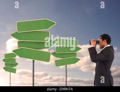 Businessman looking at empty signposts with binoculars Stock Photo - Alamy