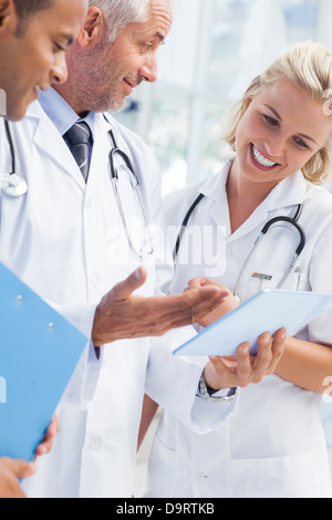 Young female doctor explaining something to a patient at desk in clinic ...