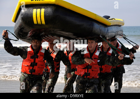Navy SEAL candidates carry a raft during surf passage exercises on the ...