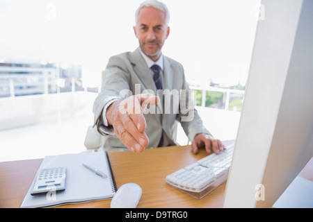 Happy businessman reaching arm out for handshake Stock Photo - Alamy