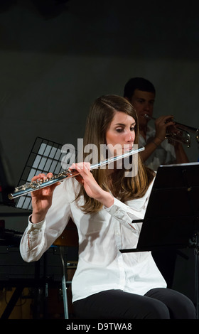Young female flutist hands playing a western type concert flute with a ...