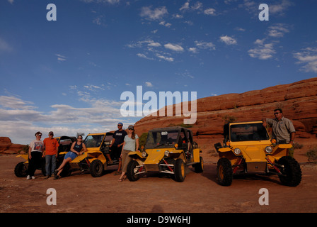 Tourists posing on tomcars little Israeli buggy jeeps at Arches ...