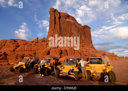 Tourists posing on tomcar a little Israeli buggy jeep at Arches ...