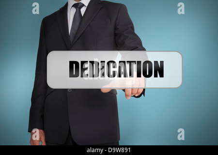Businessman selecting the word dedication written on orange tag on blue ...