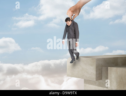 Giant hand dropping off a businessman Stock Photo - Alamy