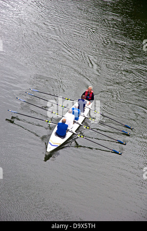 A rowing coxed four (4+) on the river Nene with Autumn covered trees in ...