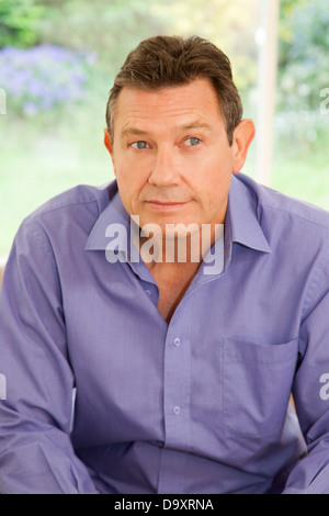 Middle-aged good looking man posing in front of a black background with ...