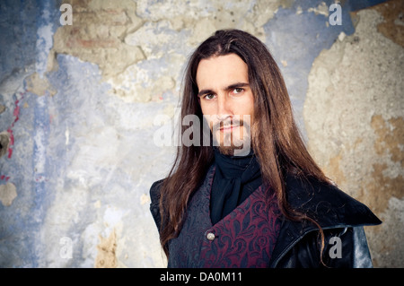 Young handsome man with long hair wearing santa claus hat over isolated ...