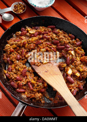 Chili con carne in frying pan on white background Stock Photo - Alamy