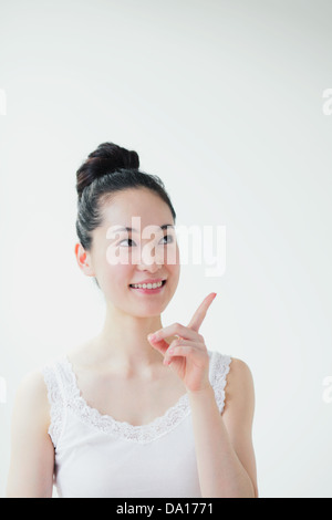 smiling woman pointing her finger up Stock Photo - Alamy