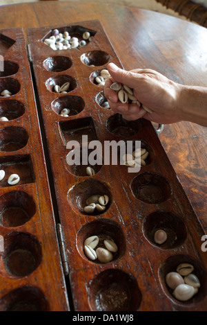 Mancala board with shells. Mancala is a traditional board game played ...